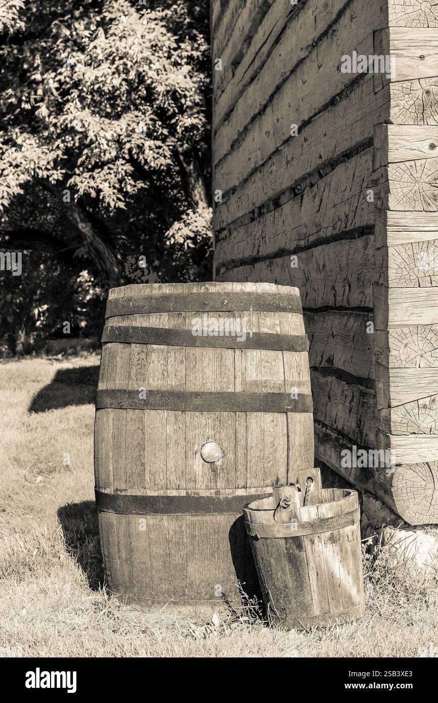 A barrel is next to a wooden shed. The barrel is old and has a wooden ...