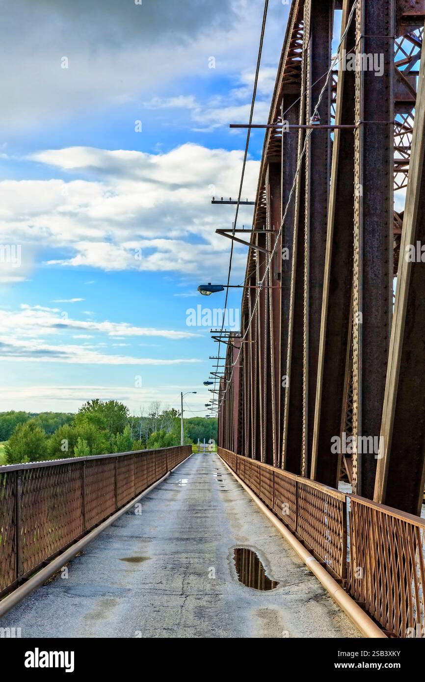 A bridge with a railing and a walkway. The railing is made of metal ...