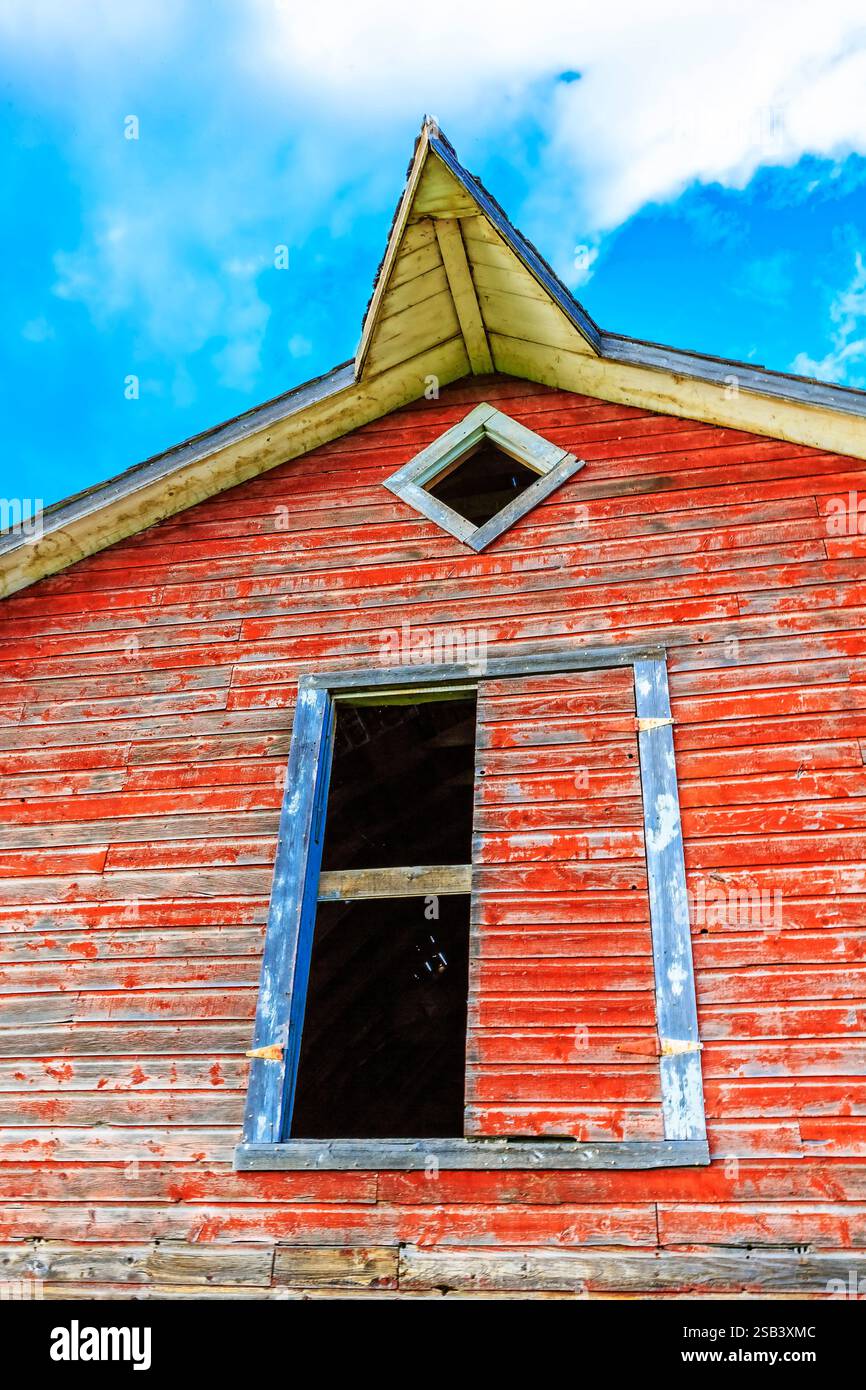 A red barn with a blue trim. The roof is slanted. The door is open. The ...
