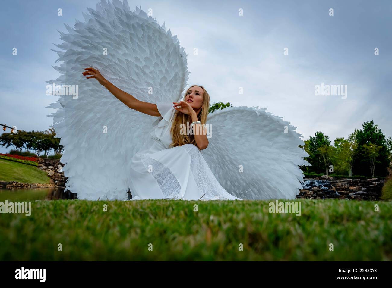 A stunning young blonde dressed in pure white, adorned with delicate ...