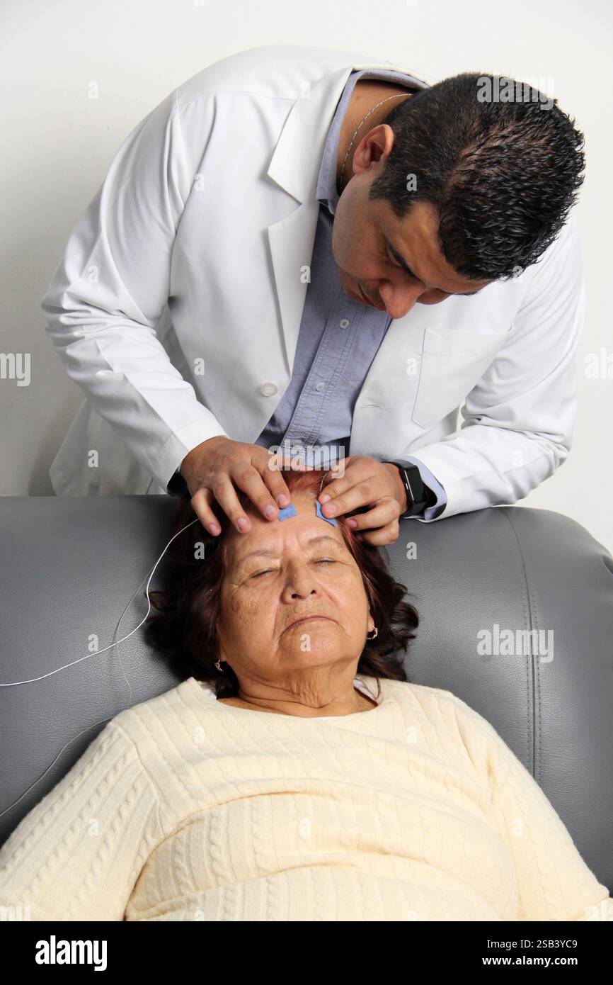 Elderly Latin woman undergoes EEG electroencephalogram to detect dementia or Alzheimer's disease ...