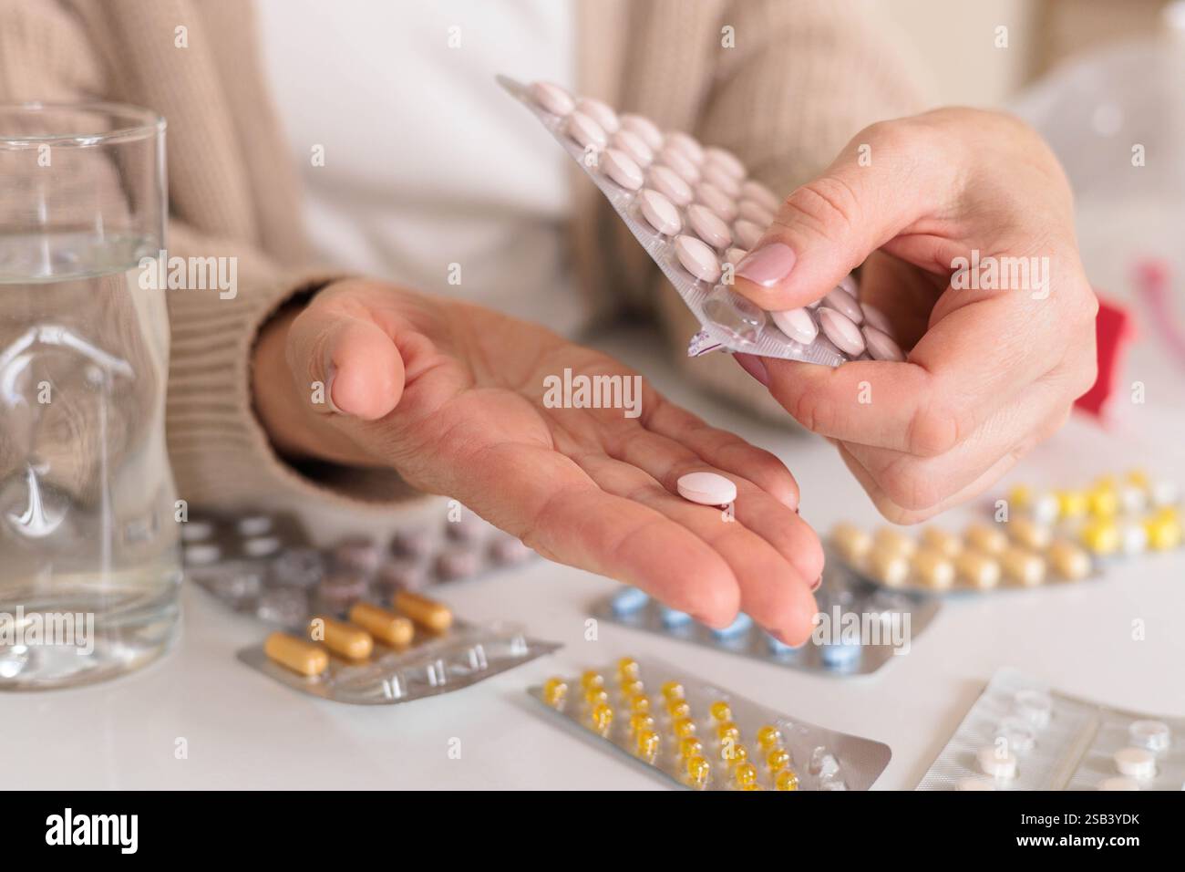 Female hands close up hold pink hormonal and contraceptive pill from ...