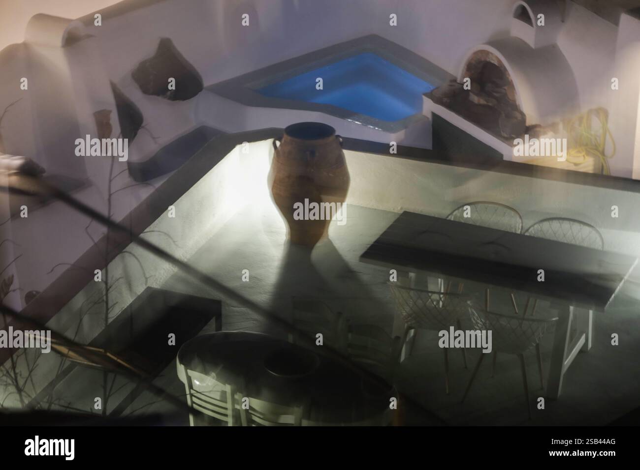 A surreal, nighttime scene featuring an outdoor patio with a large ...