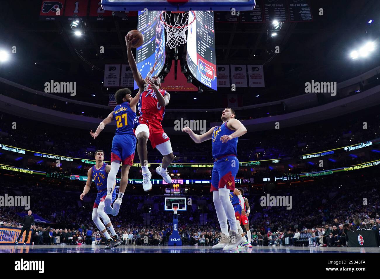 Philadelphia 76ers' Tyrese Maxey (0) goes up for a shot between Denver ...