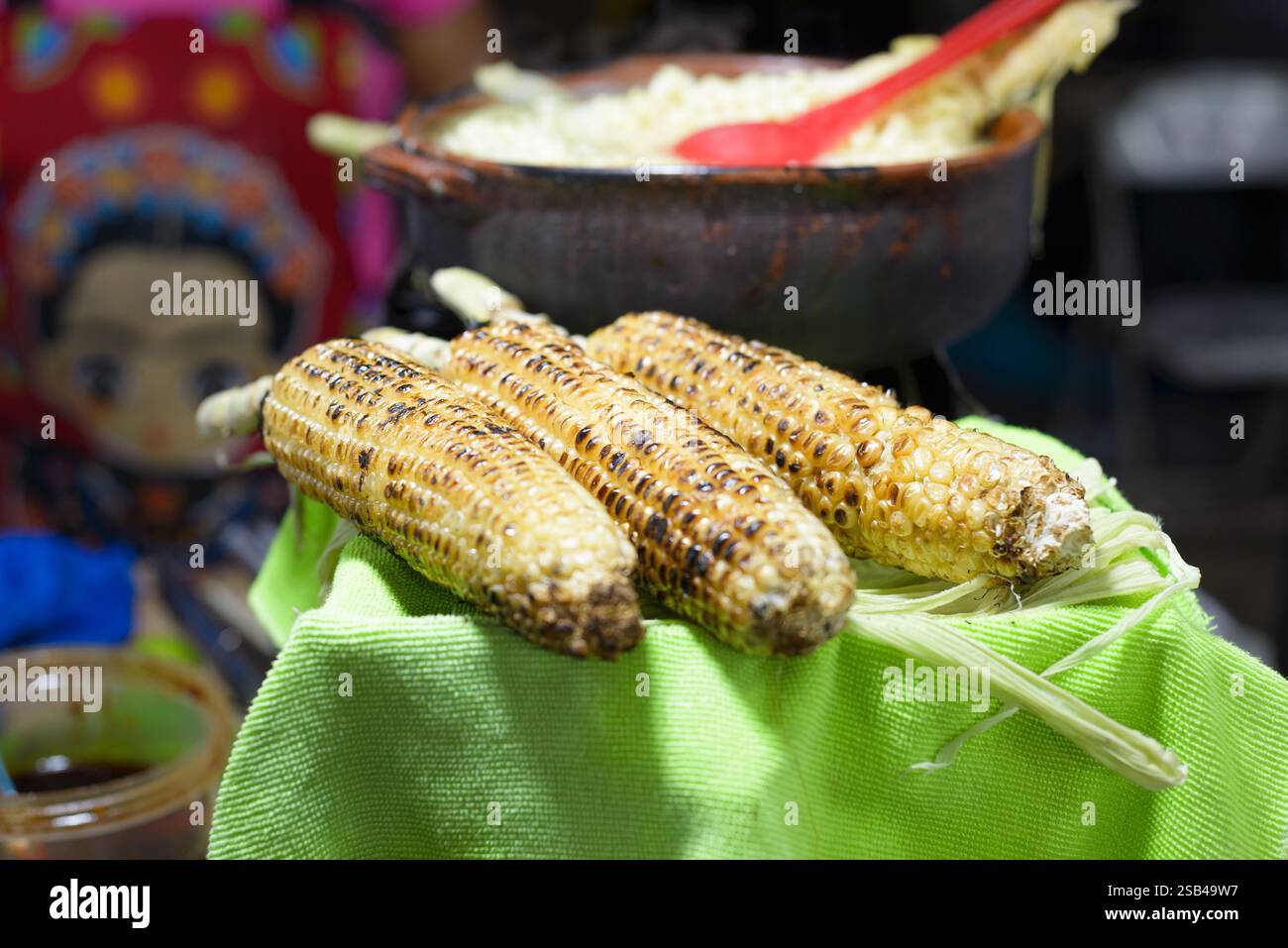 Elote roasted on charcoal at a street food stall in Mexico. Roasted ...