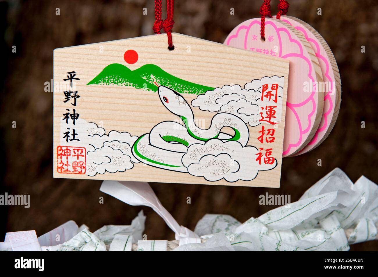 A wooden "ema" (prayer plaque) depicting the Year of the Snake seen ...