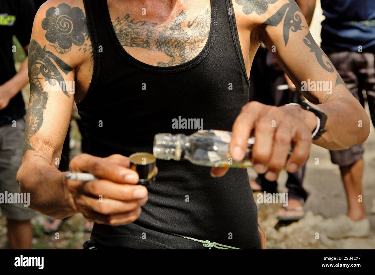 A man pouring an energy drink made in Malaysia, during an ecotourism ...