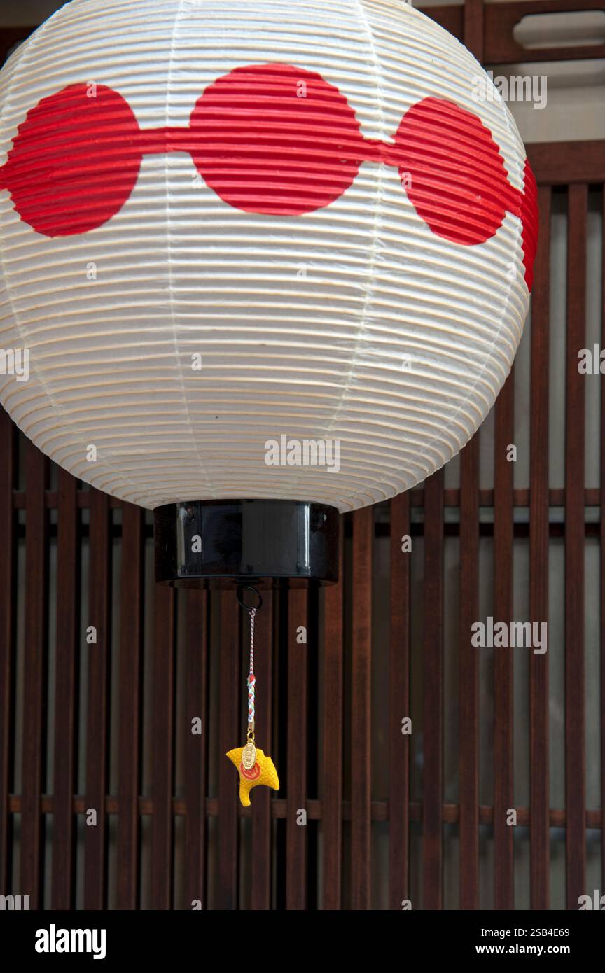 Hanging "chochin" paper lantern with red dot design and stabilizing ...