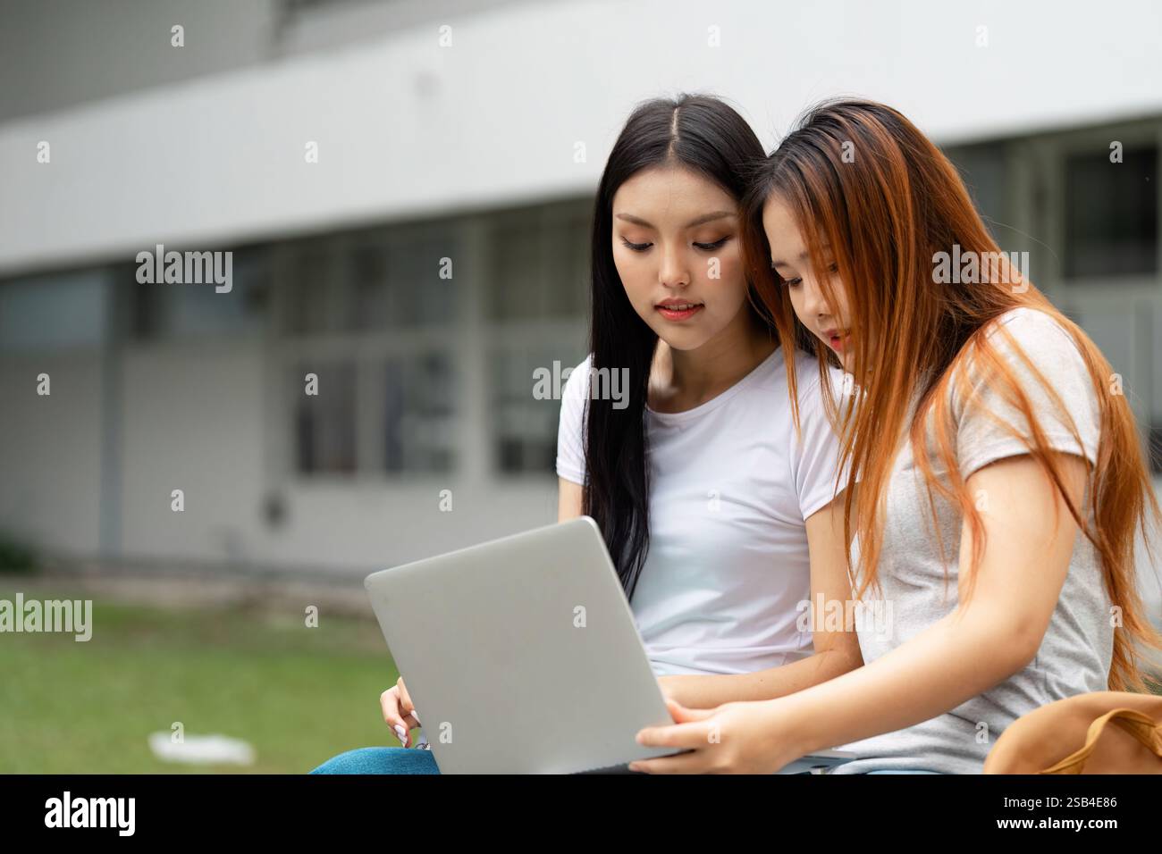 Focused students collaborating on a laptop in an outdoor learning ...