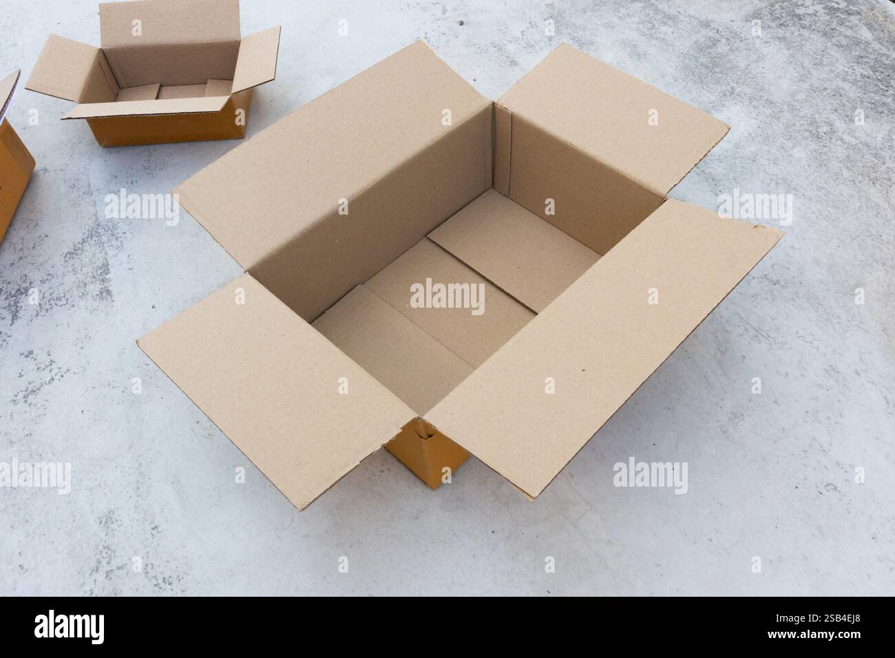 Open empty brown cardboard box on concrete floor Stock Photo - Alamy
