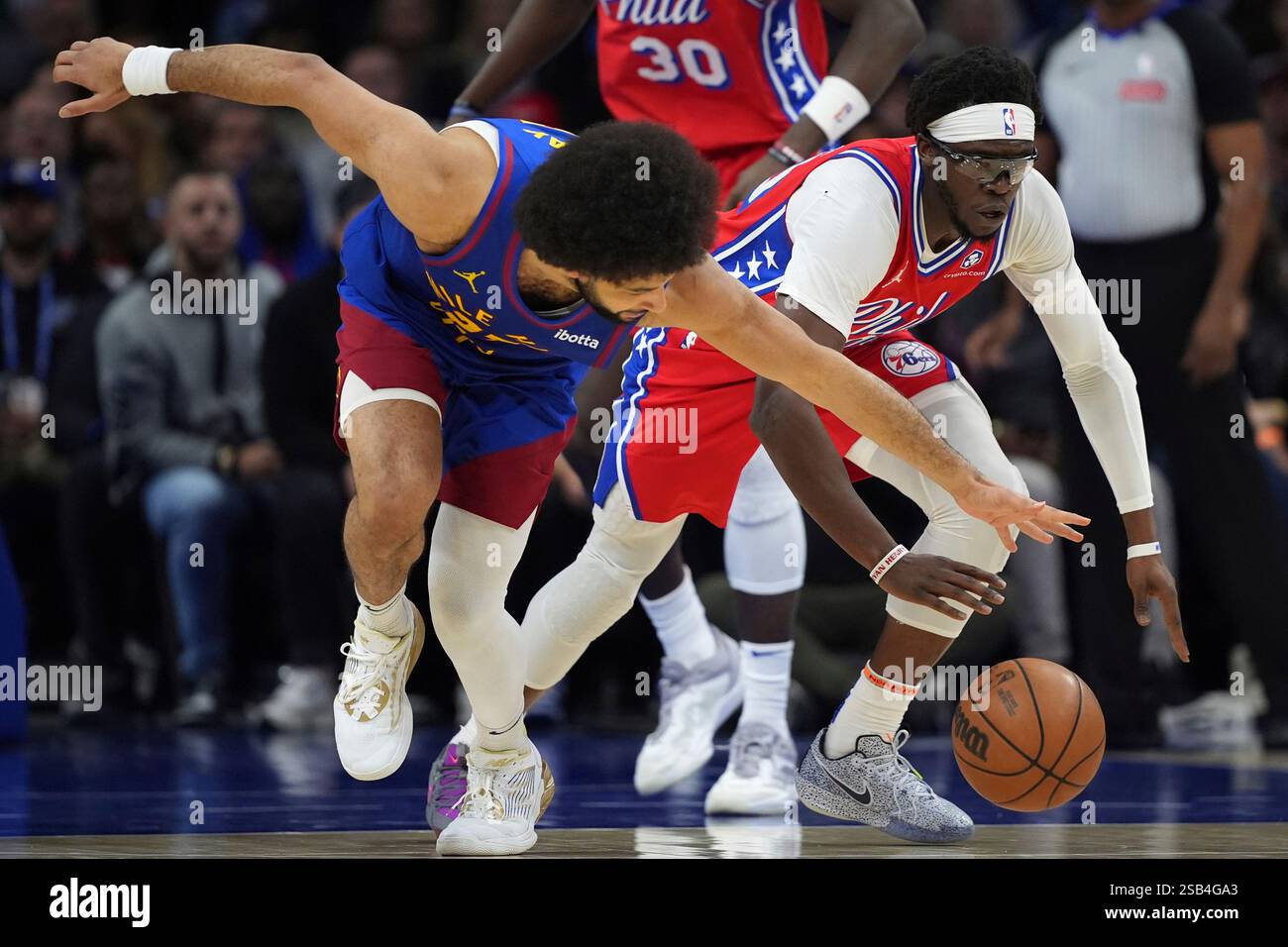 Denver Nuggets' Jamal Murray, left, and Philadelphia 76ers' Reggie Jackson chase a loose ball ...