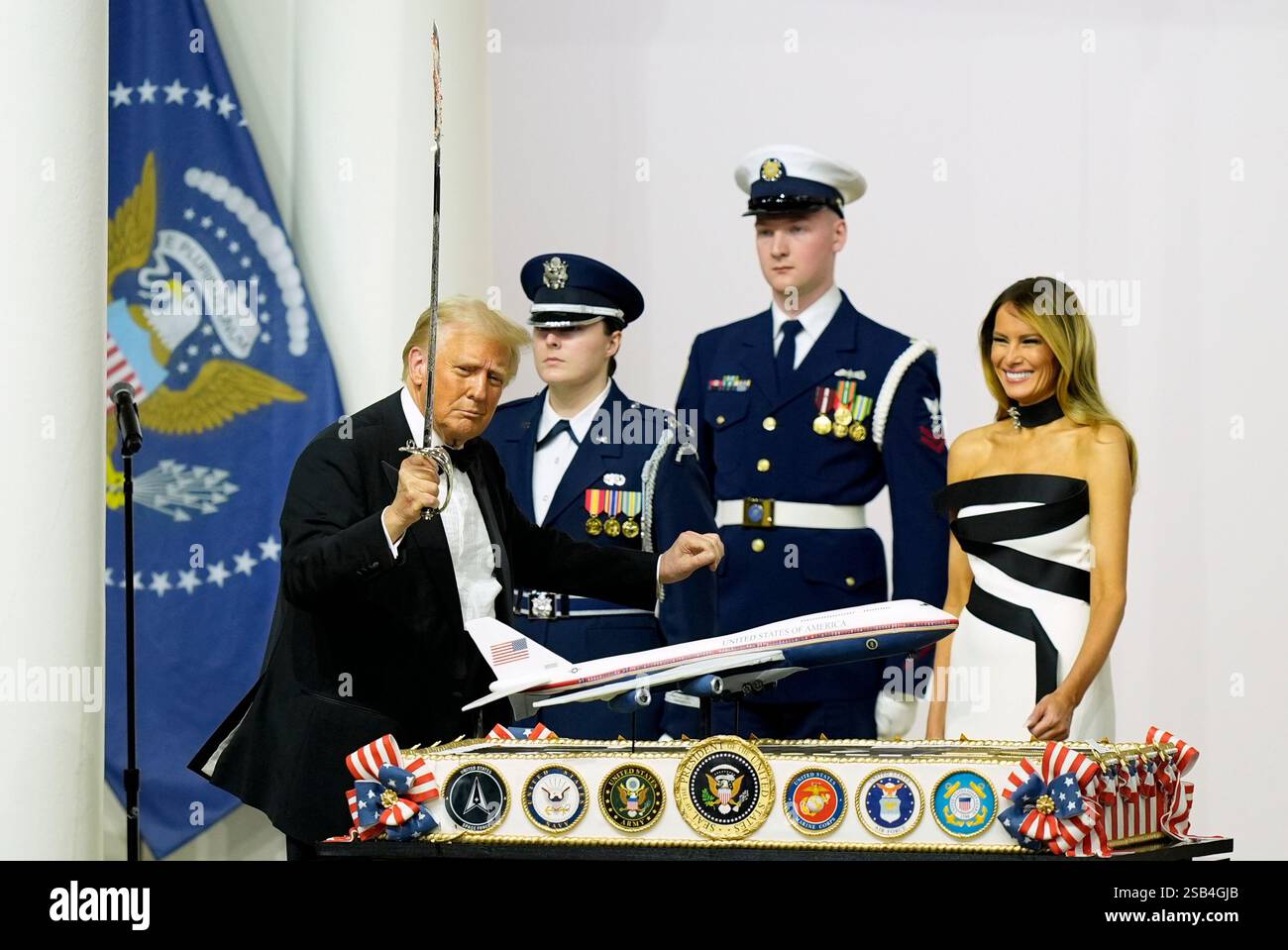 U.S. President Donald Trump holds up a sword after using it to cut the ...