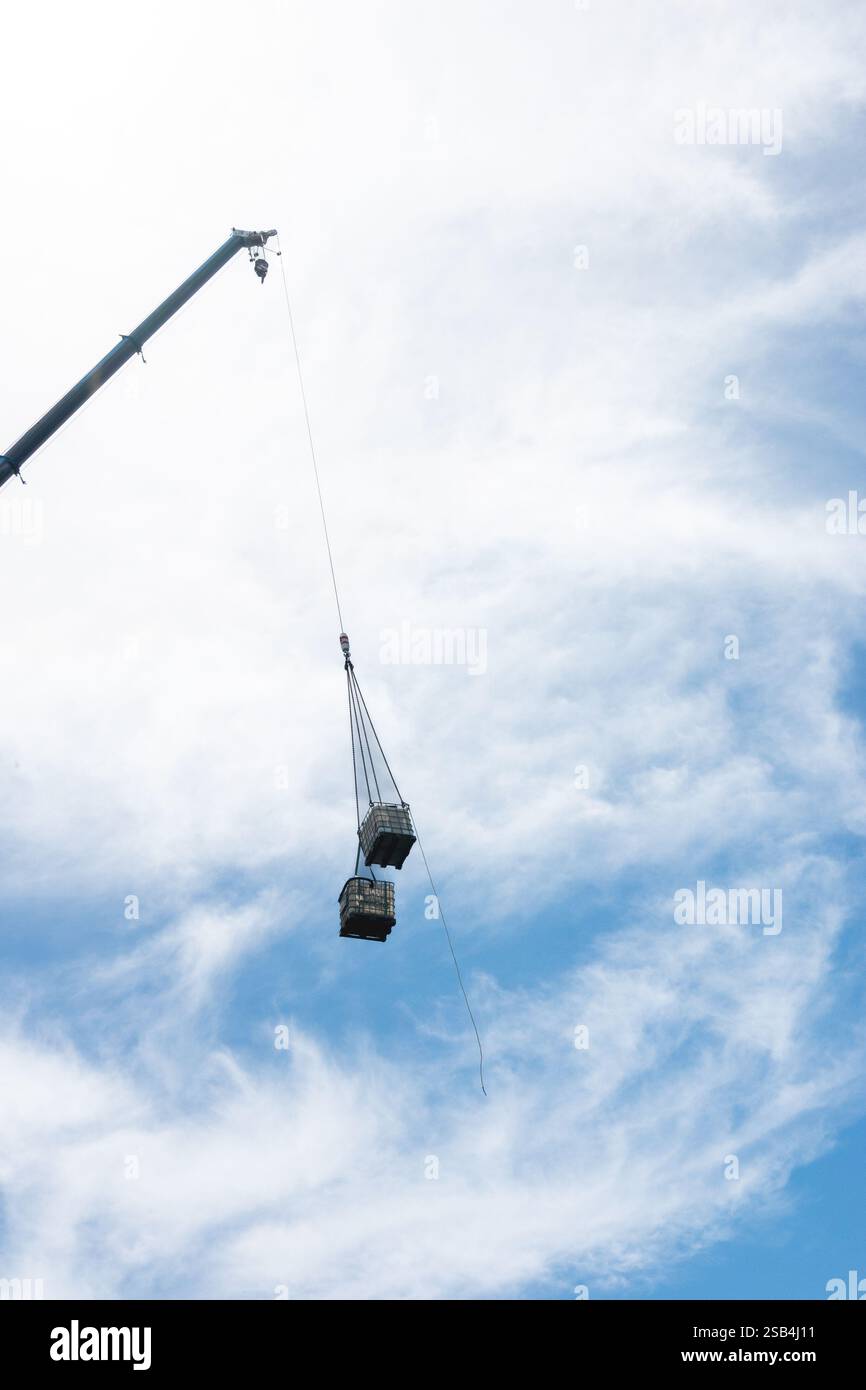 Low point of view of crane lifting load high into sky Stock Photo - Alamy