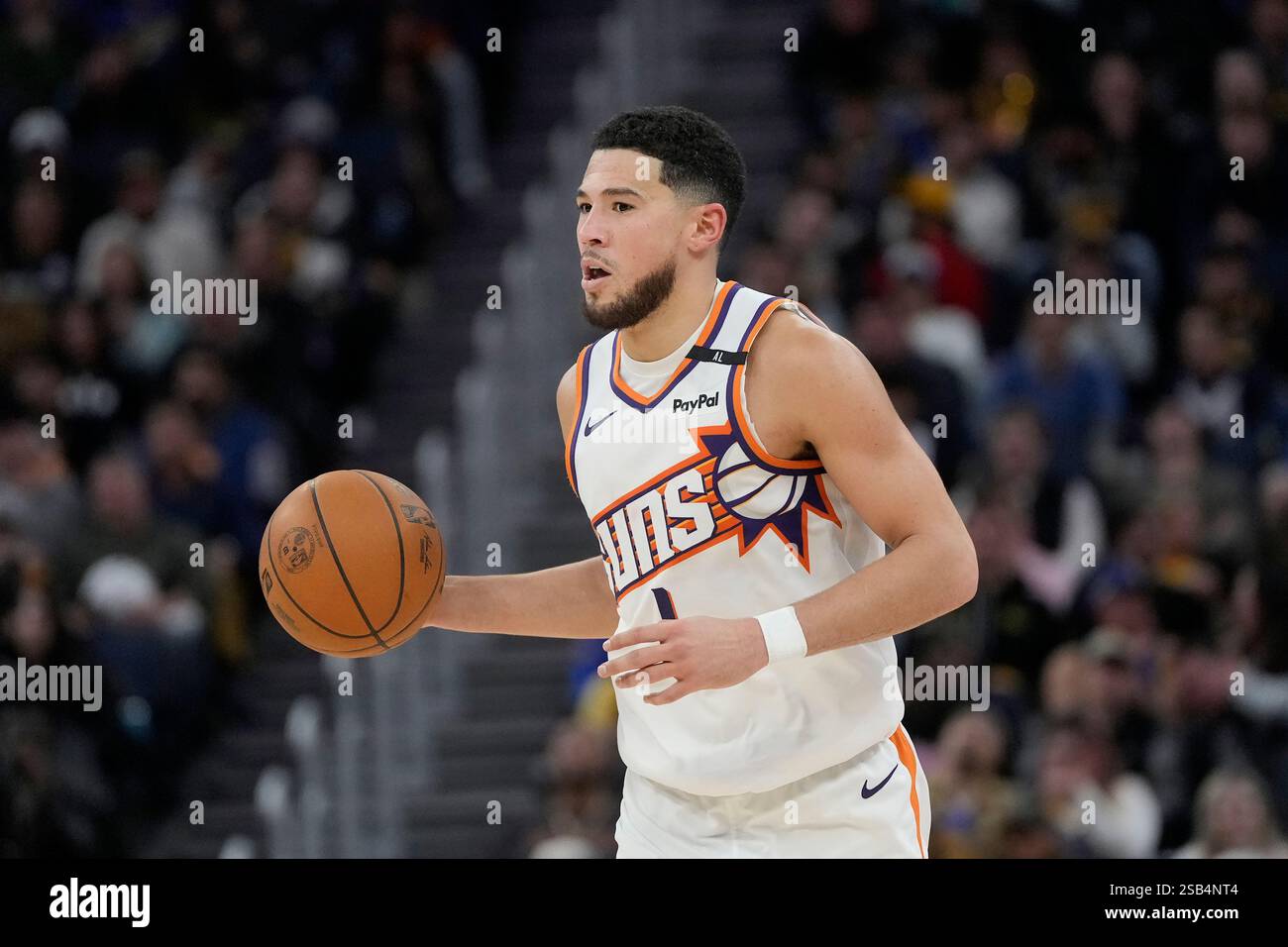 Phoenix Suns guard Devin Booker brings the ball up the court against ...