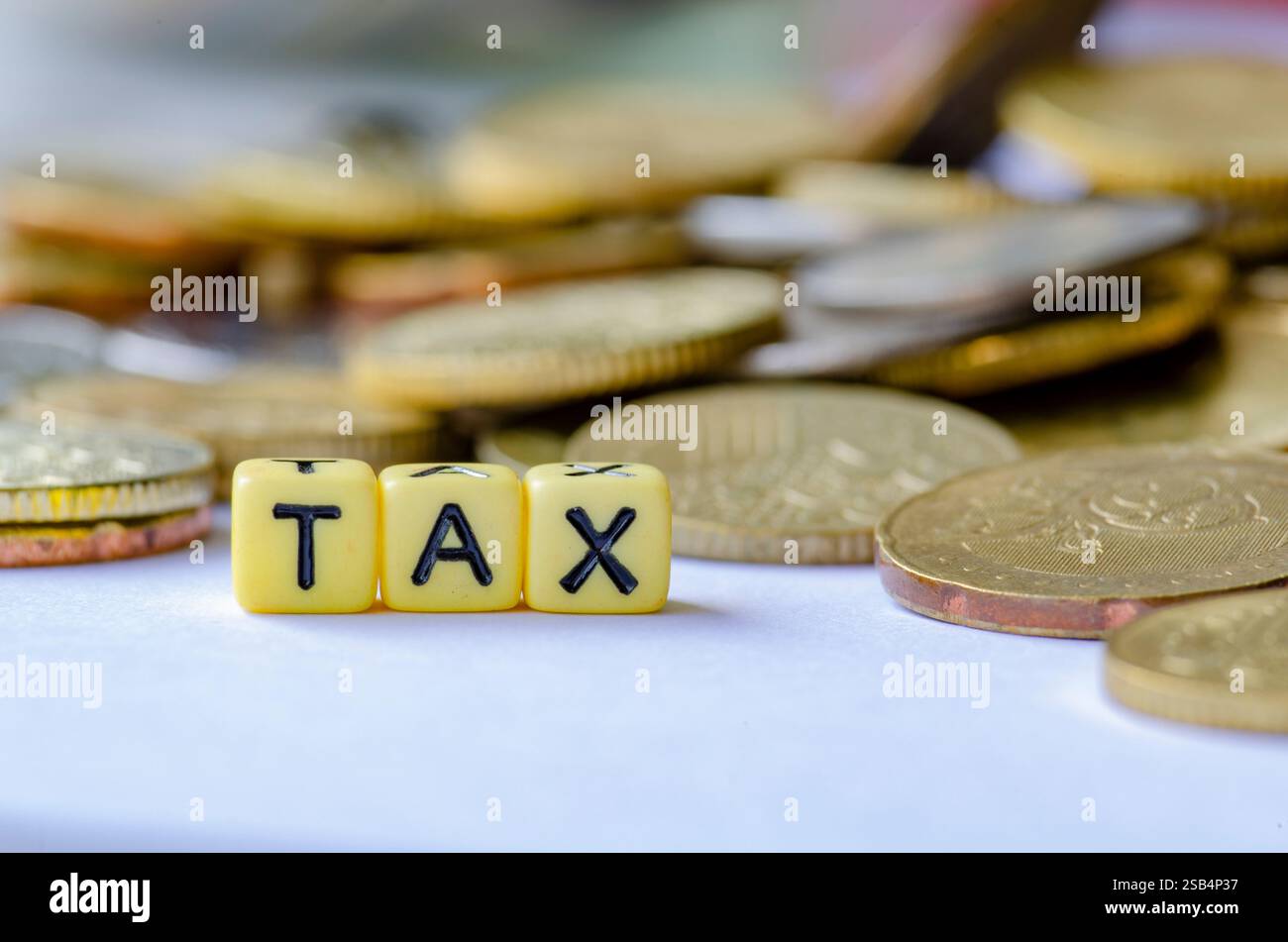 TAX text on colorful plastic alphabet beads with golden coins ...
