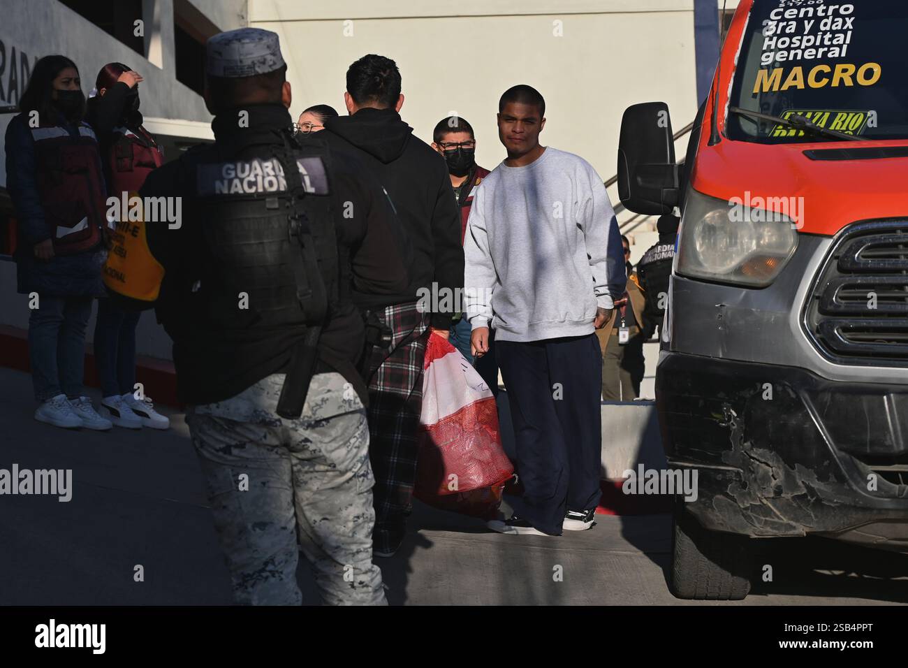 A deported migrant get off a government paid private taxi bus to walk ...
