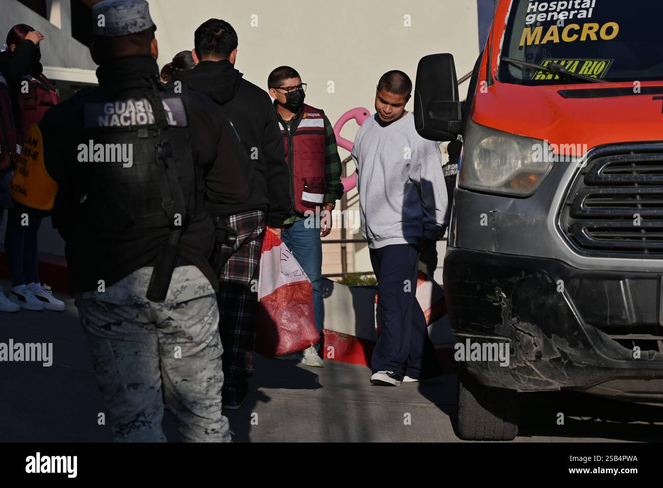 A deported migrant get off a government paid private taxi bus to walk ...