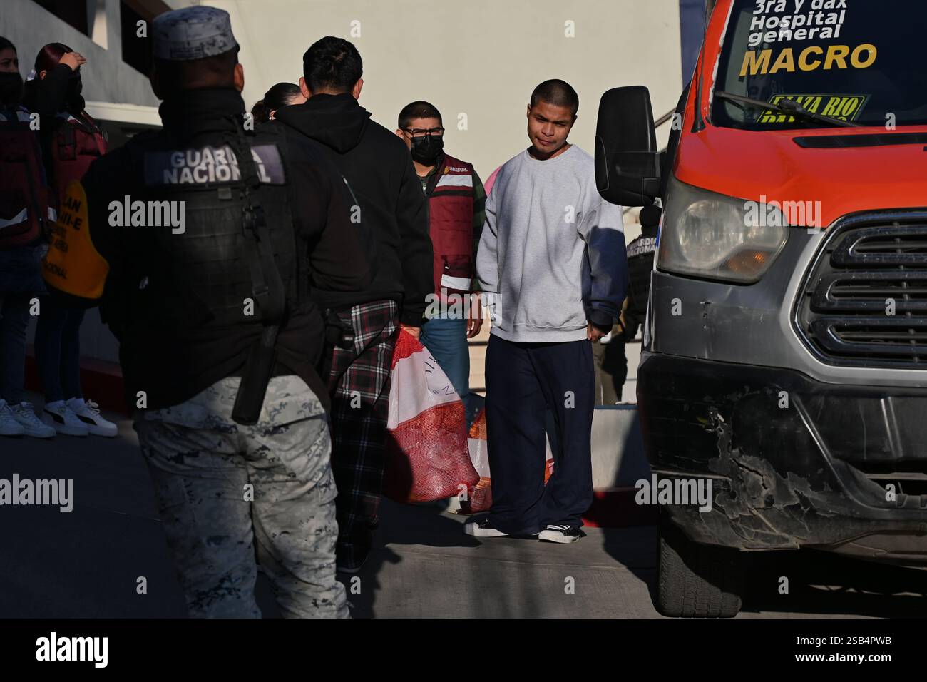 A deported migrant get off a government paid private taxi bus to walk ...