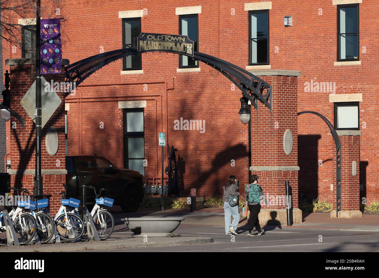 Two visitors walk past an entrance to the Old Town Marketplace, Friday ...