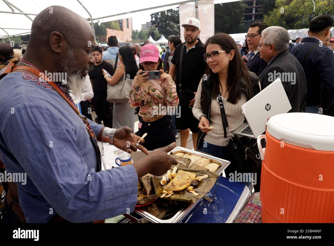 A vendor offers a tamale to a person at the first Tamale Fair as part ...