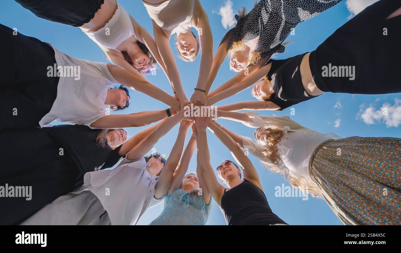 High school students joining hands in a circle, representing teamwork ...