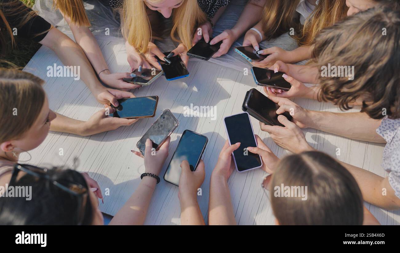 Group of young friends are using their smartphones together, creating a ...