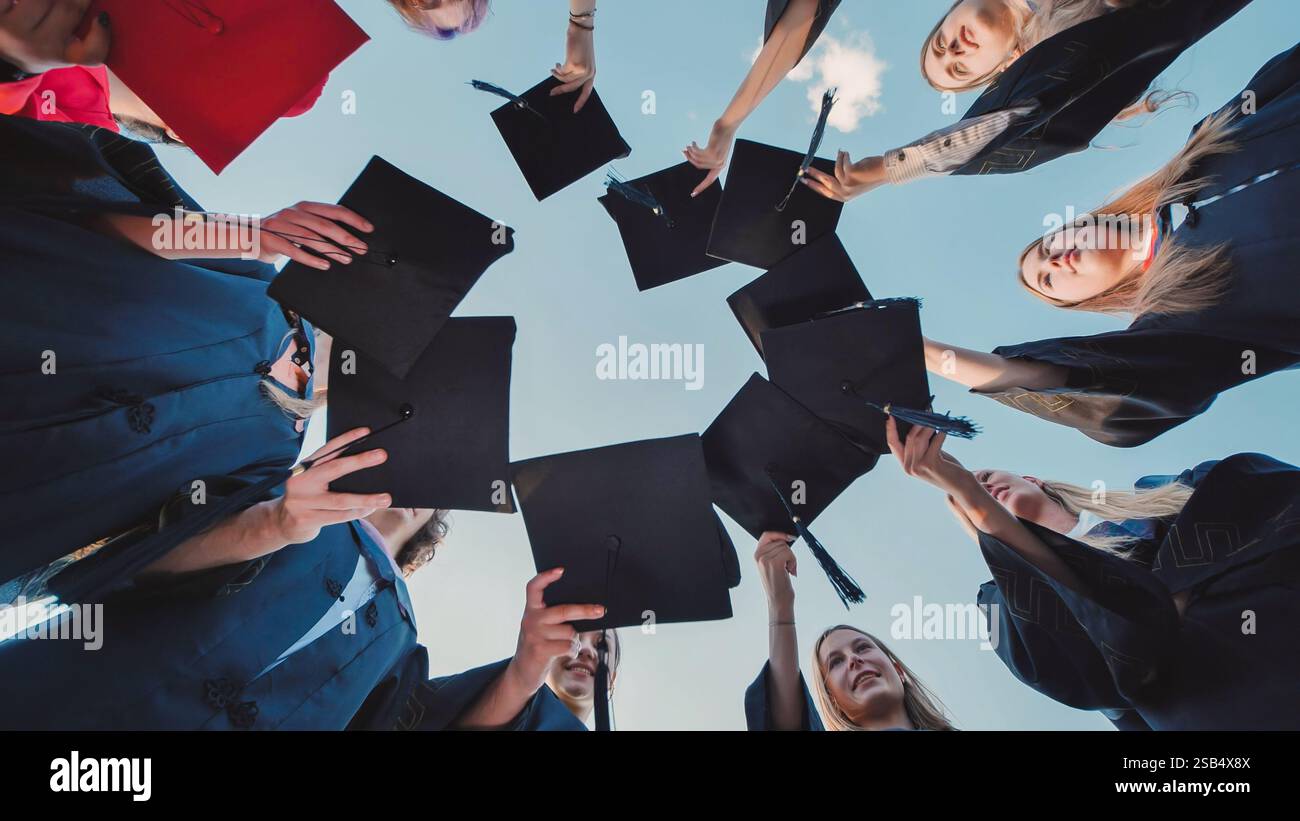 Happy students in academic gowns tossing their mortarboards in the air ...
