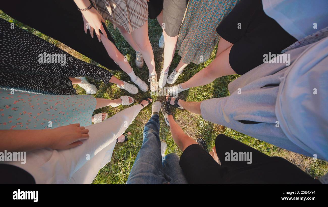 Group of high school students forming a circle on grass, showing unity ...