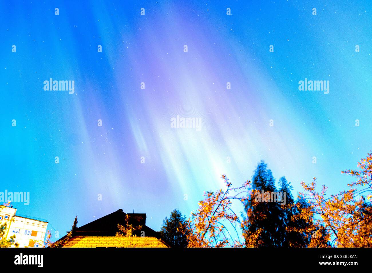 landscape with gorgeous northern lights over the roof of the house ...