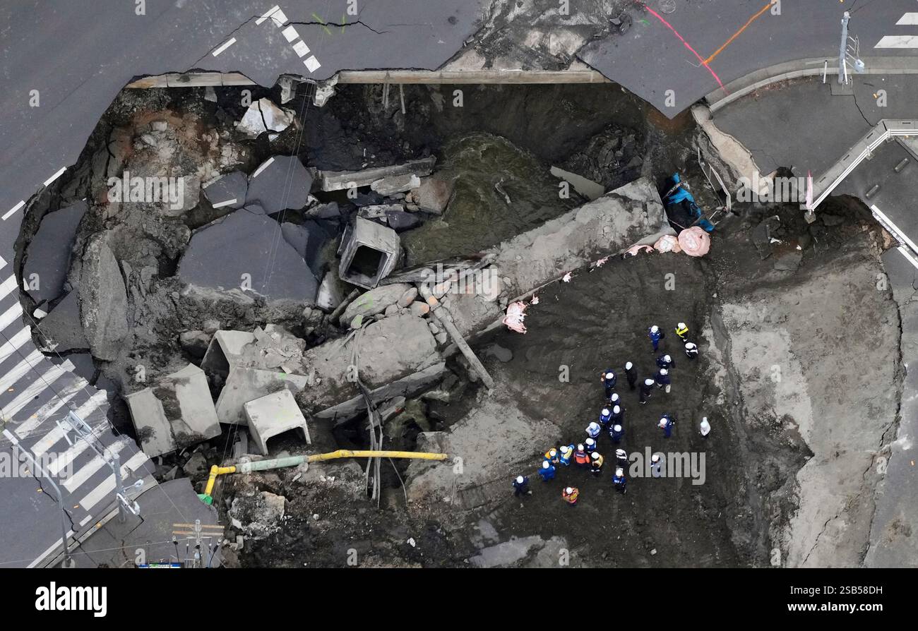 An aerial photo shows the site of a road collapsed above huge sinkholes ...