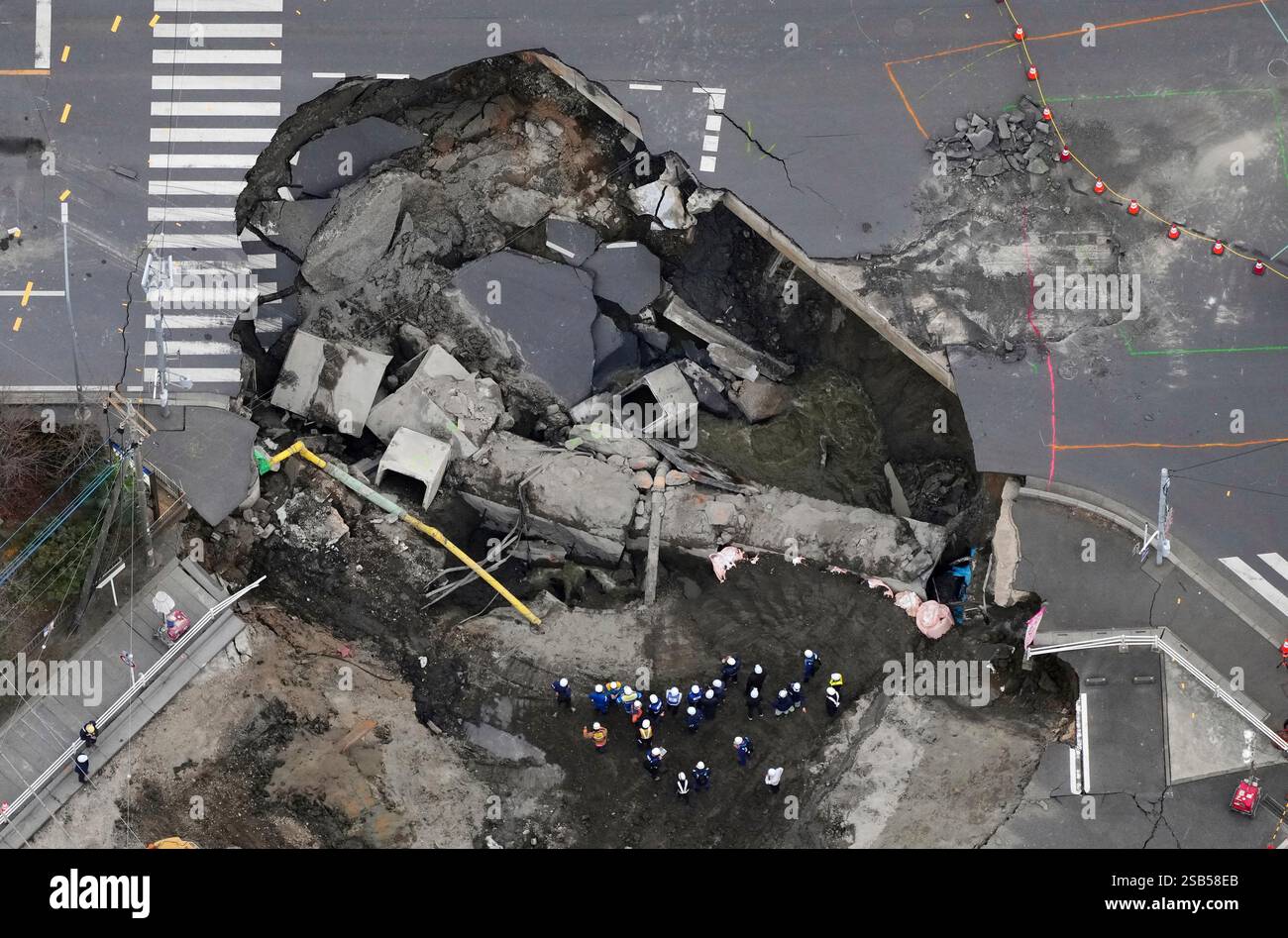 An aerial photo shows the site of a road collapsed above huge sinkholes ...