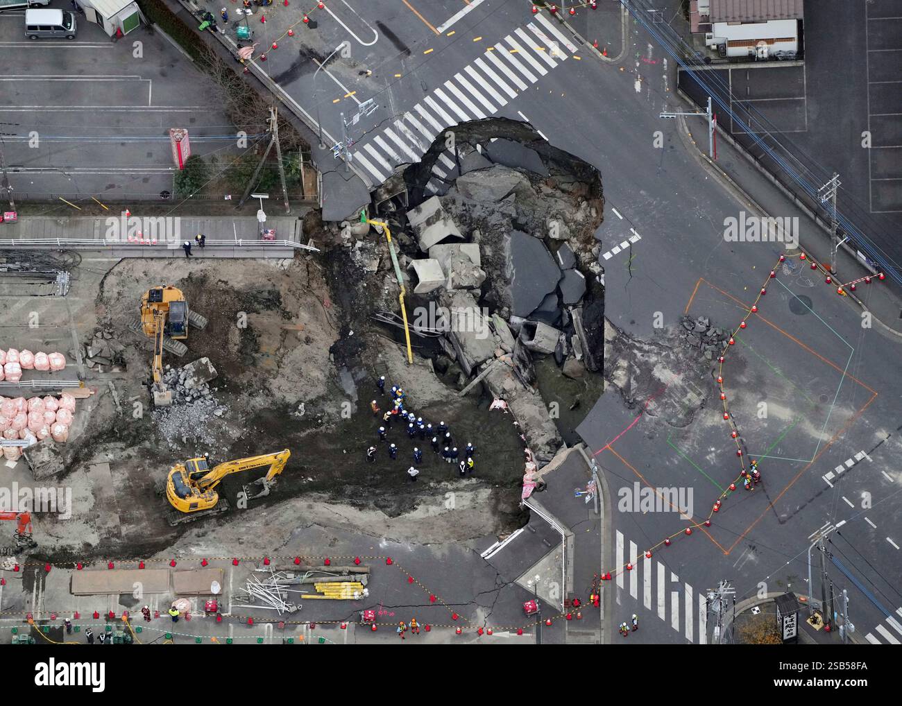 An aerial photo shows the site of a road collapsed above huge sinkholes ...