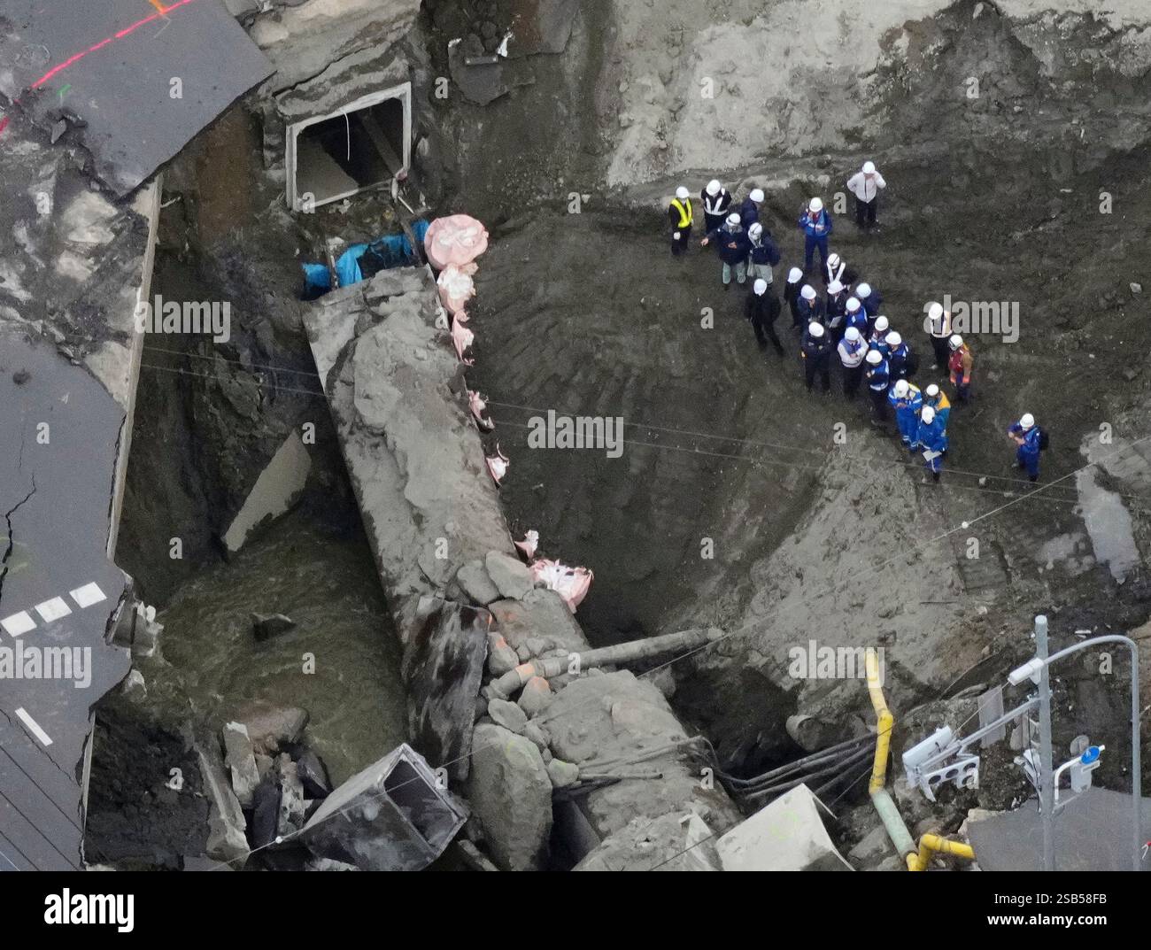 An aerial photo shows the site of a road collapsed above huge sinkholes ...