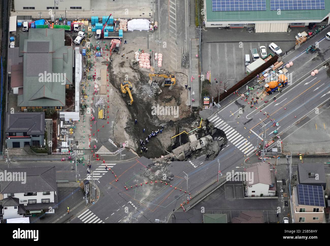An aerial photo shows the site of a road collapsed above huge sinkholes ...