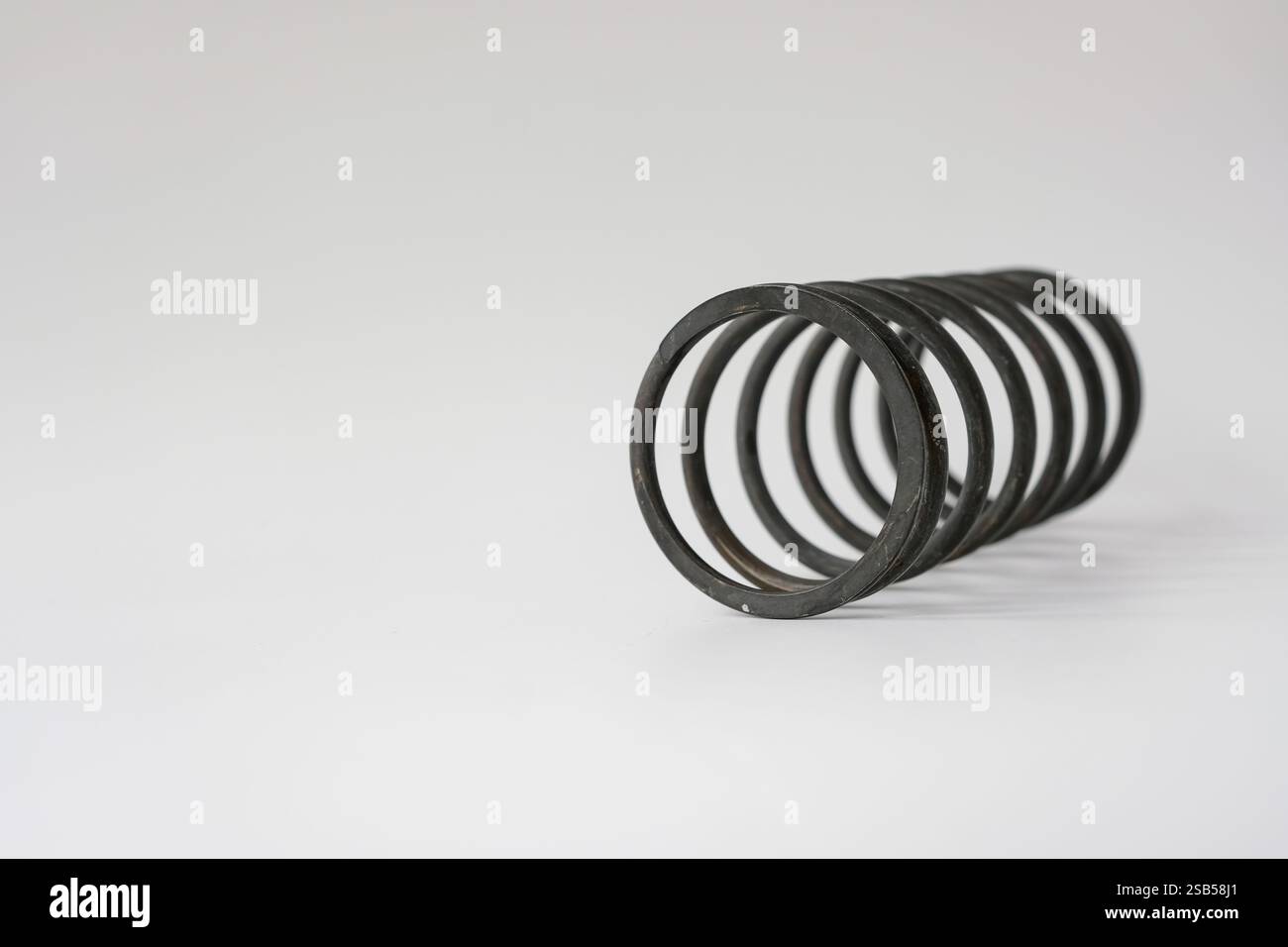 Metal spring on a white background. Production and use of springs in ...