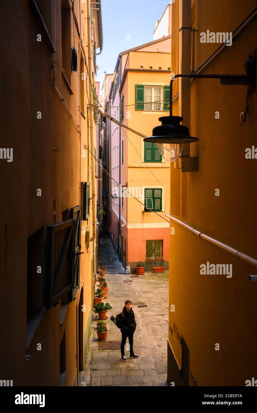 Perspective view on downhill thin street with tourist in Genoa, Liguria ...