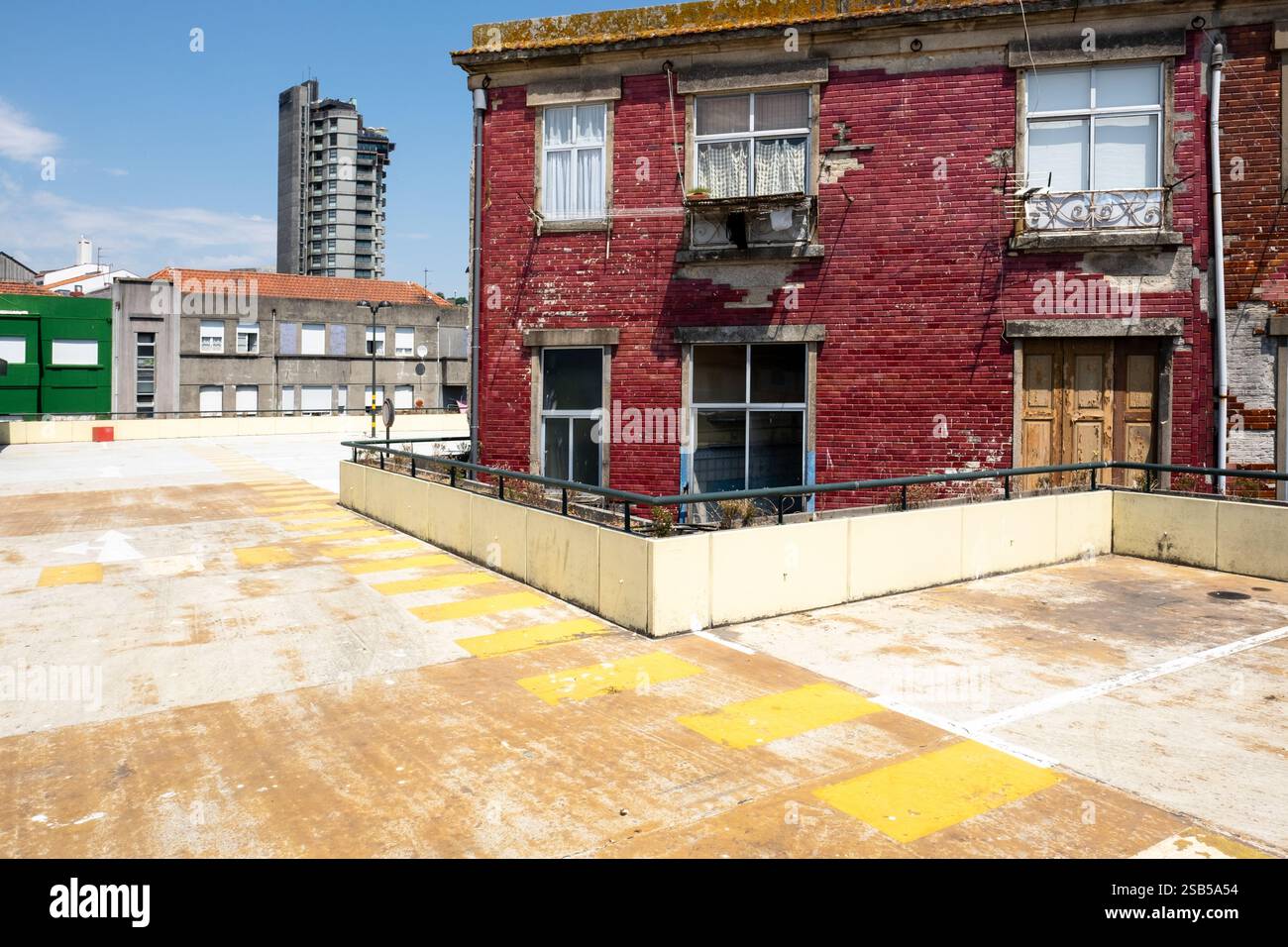Old building with wall of bricks nestled in a multi floor parking ...