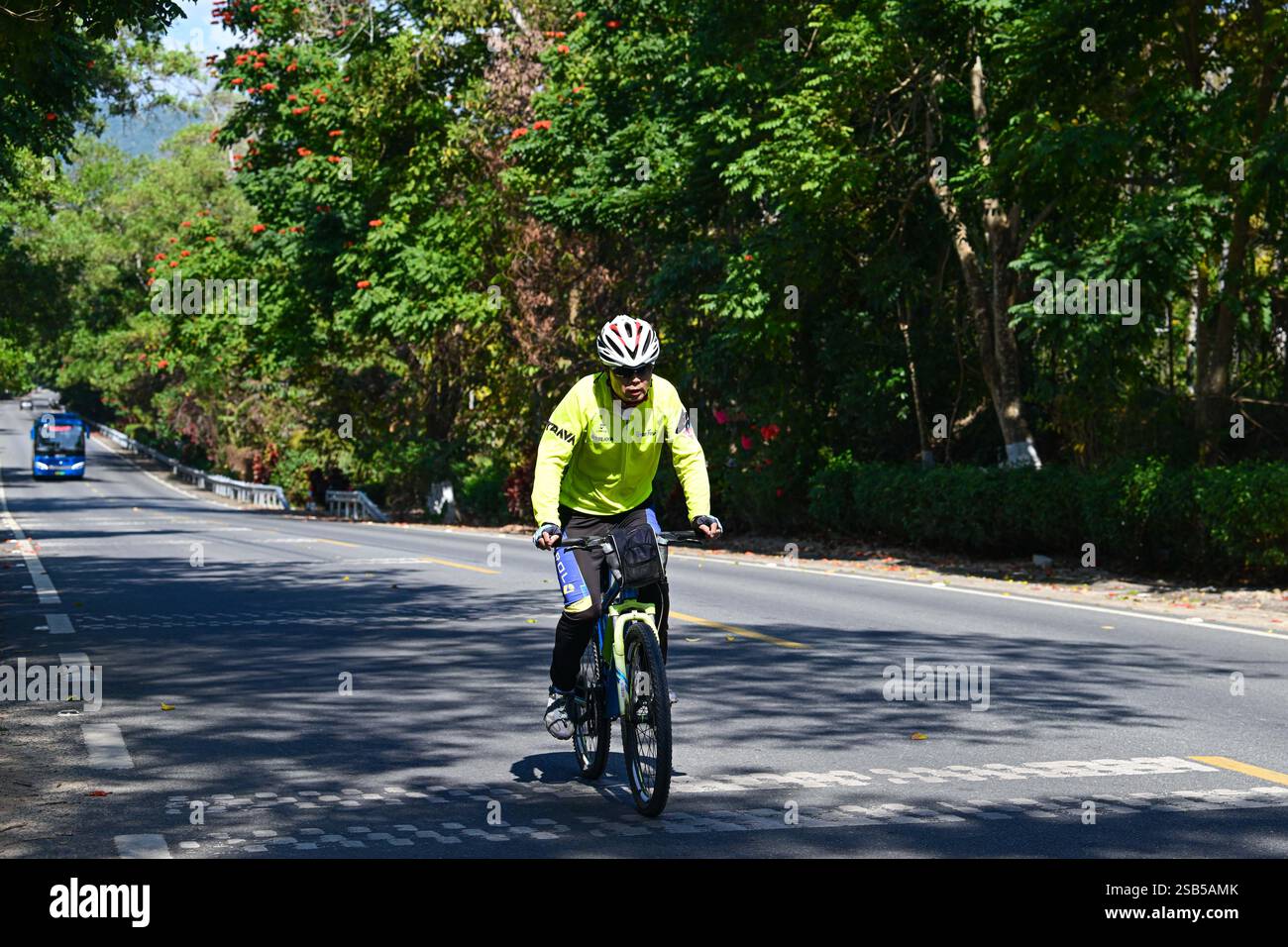 Haikou. 30th Jan, 2025. A man rides a bike on a scenic ring road ...