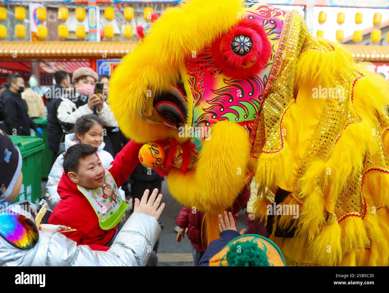 A child interacts with a lion dance performance at Dabao Island ...