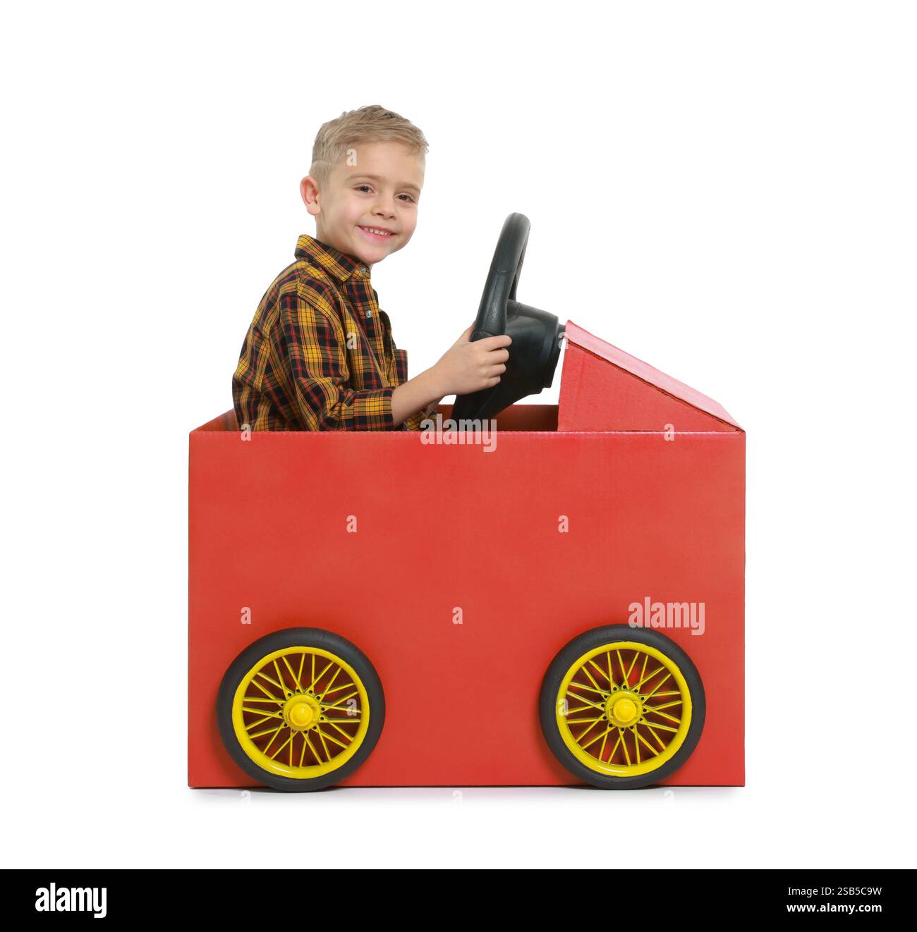 Little boy driving car made of cardboard on white background Stock ...