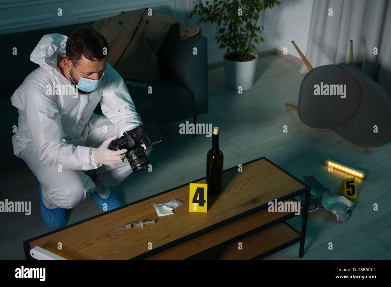 Forensic expert with camera taking photo of evidences at crime scene ...