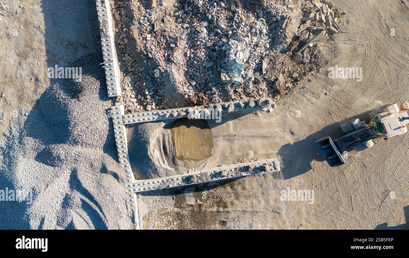 Aerial view of a construction site with a large pile of rubble and a ...