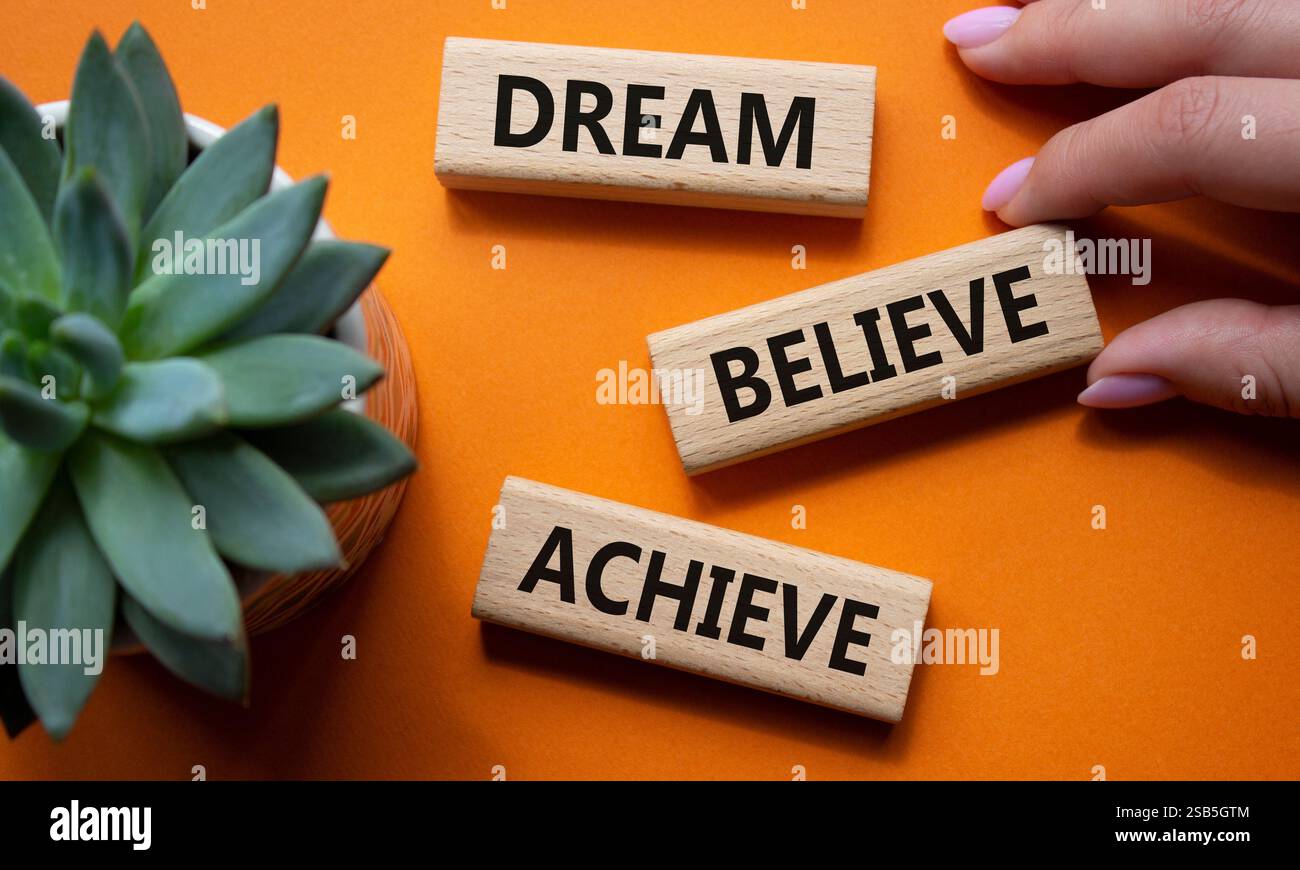 Dream Believe Achieve symbol. Wooden blocks with words Dream Believe ...