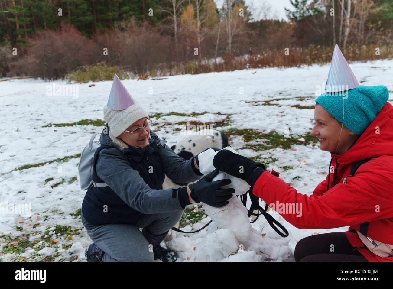 Joyful moments creating a snowman with friends in a snowy park during ...