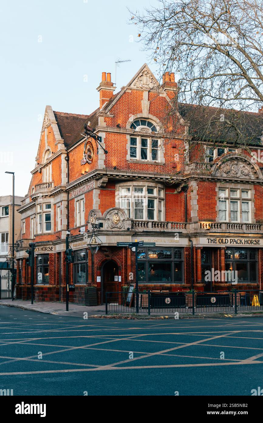 A classic red brick pub stands prominently at the corner of a bustling ...