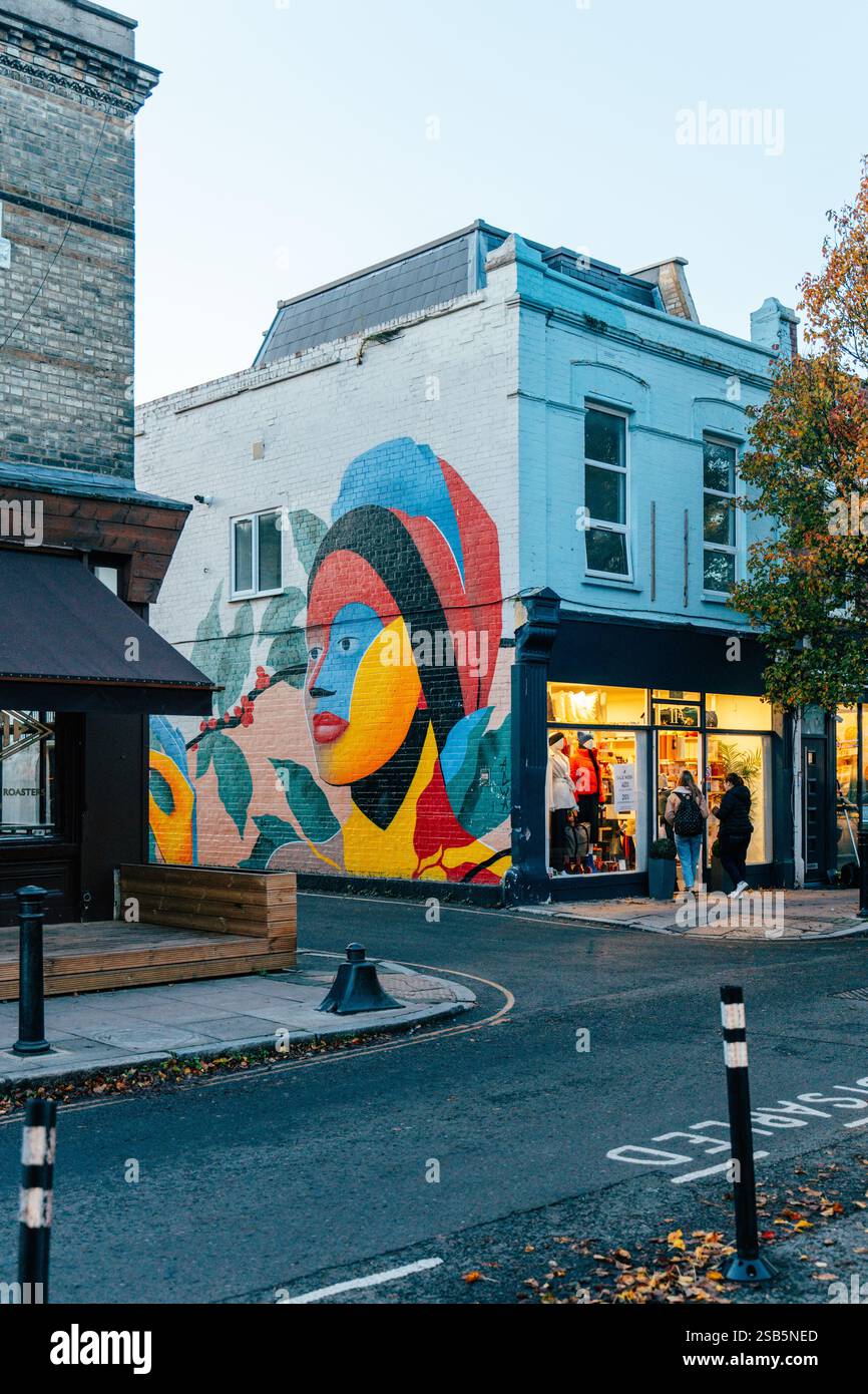 Colorful mural adorns a building at a busy street corner, attracting ...