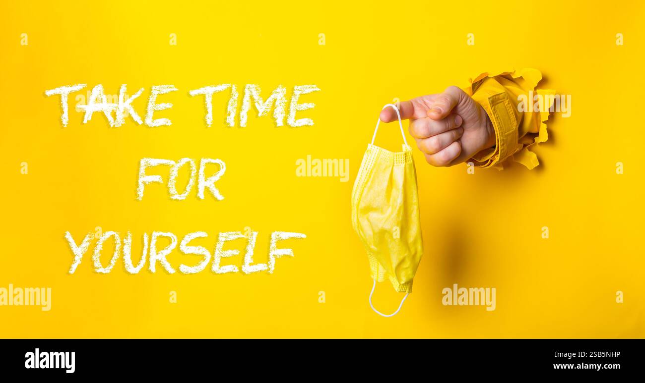Person holding a yellow mask with the words Take time for yourself ...