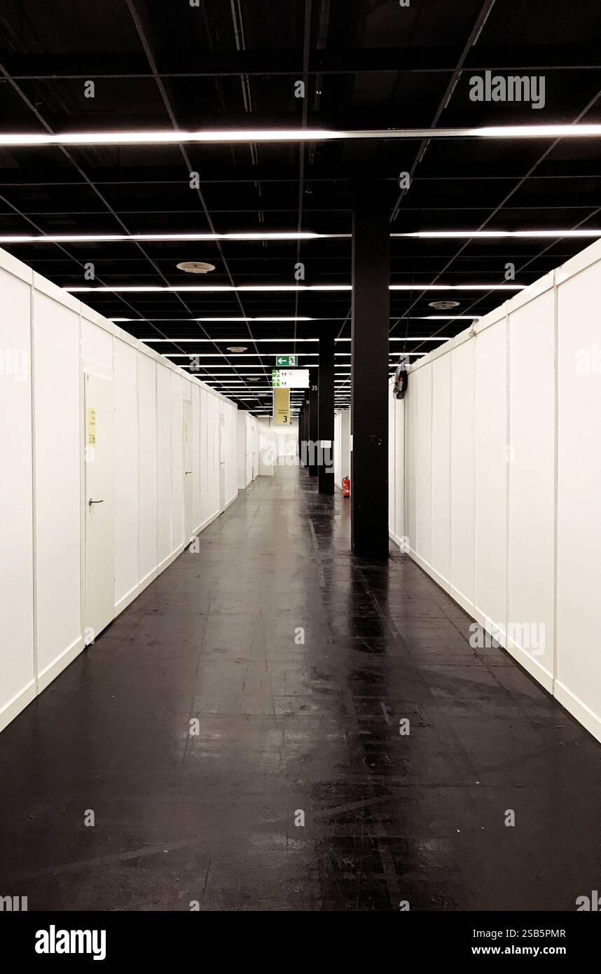 Long hallway with a black floor and white walls. refugee camp in ...