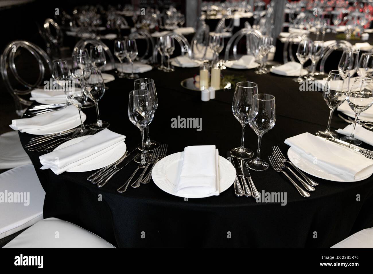 Close-up of an elegant round table setup, plates, glasses, and food ...