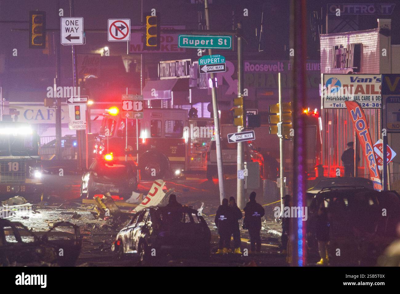 FBI officials in marked jackets stand near debris from medical jet ...